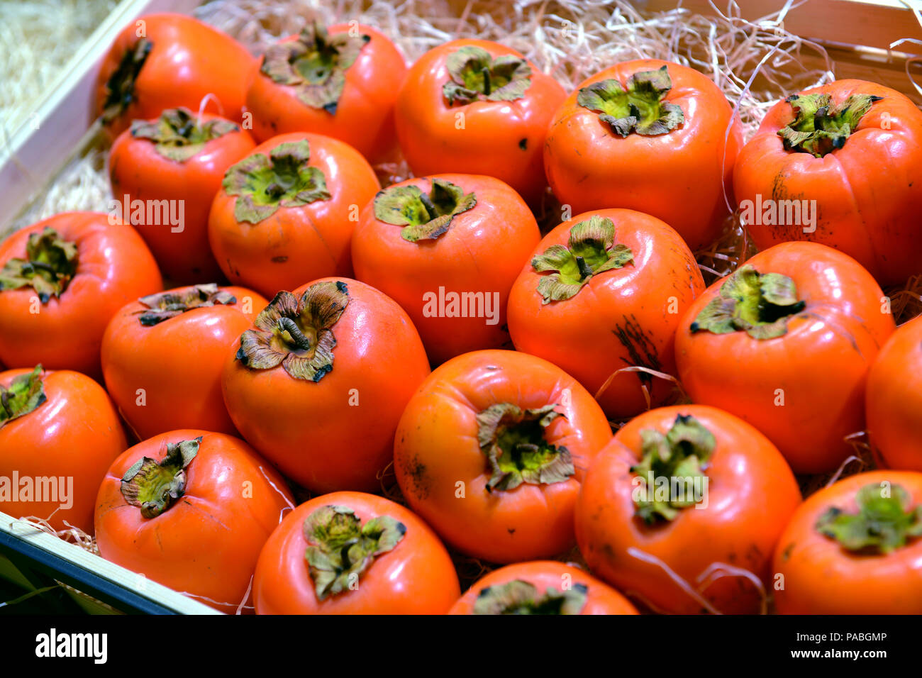 persimmon in a box on the counter Stock Photo - Alamy