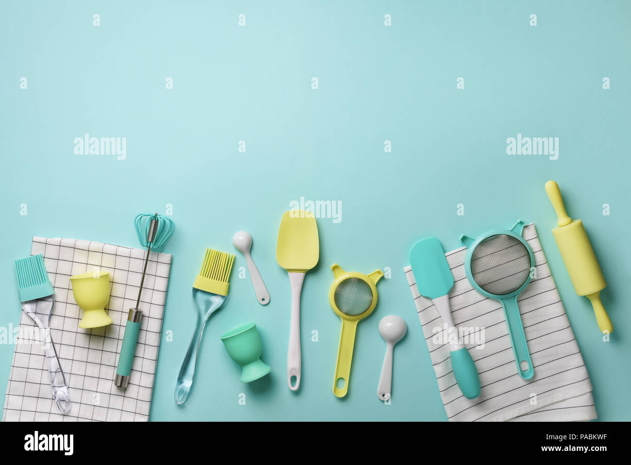 Time to cook. Pastel yellow, blue cooking utensils on turquoise ...