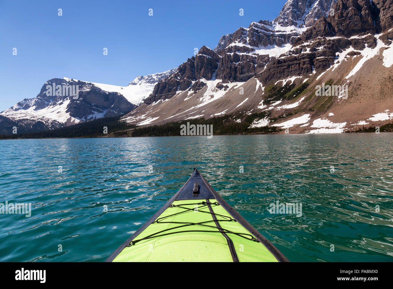 Kayaking in a glacier lake during a vibrant sunny summer day. Taken in ...