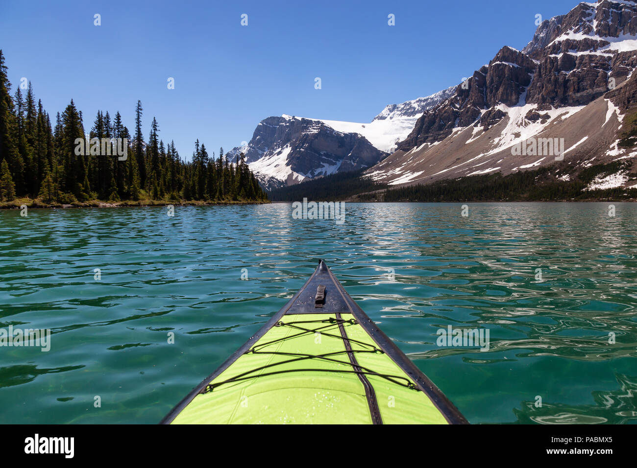 Kayaking in a glacier lake during a vibrant sunny summer day. Taken in ...