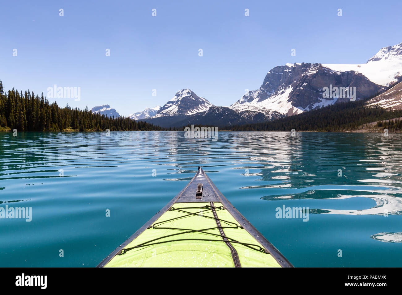 Kayaking in a glacier lake during a vibrant sunny summer day. Taken in ...