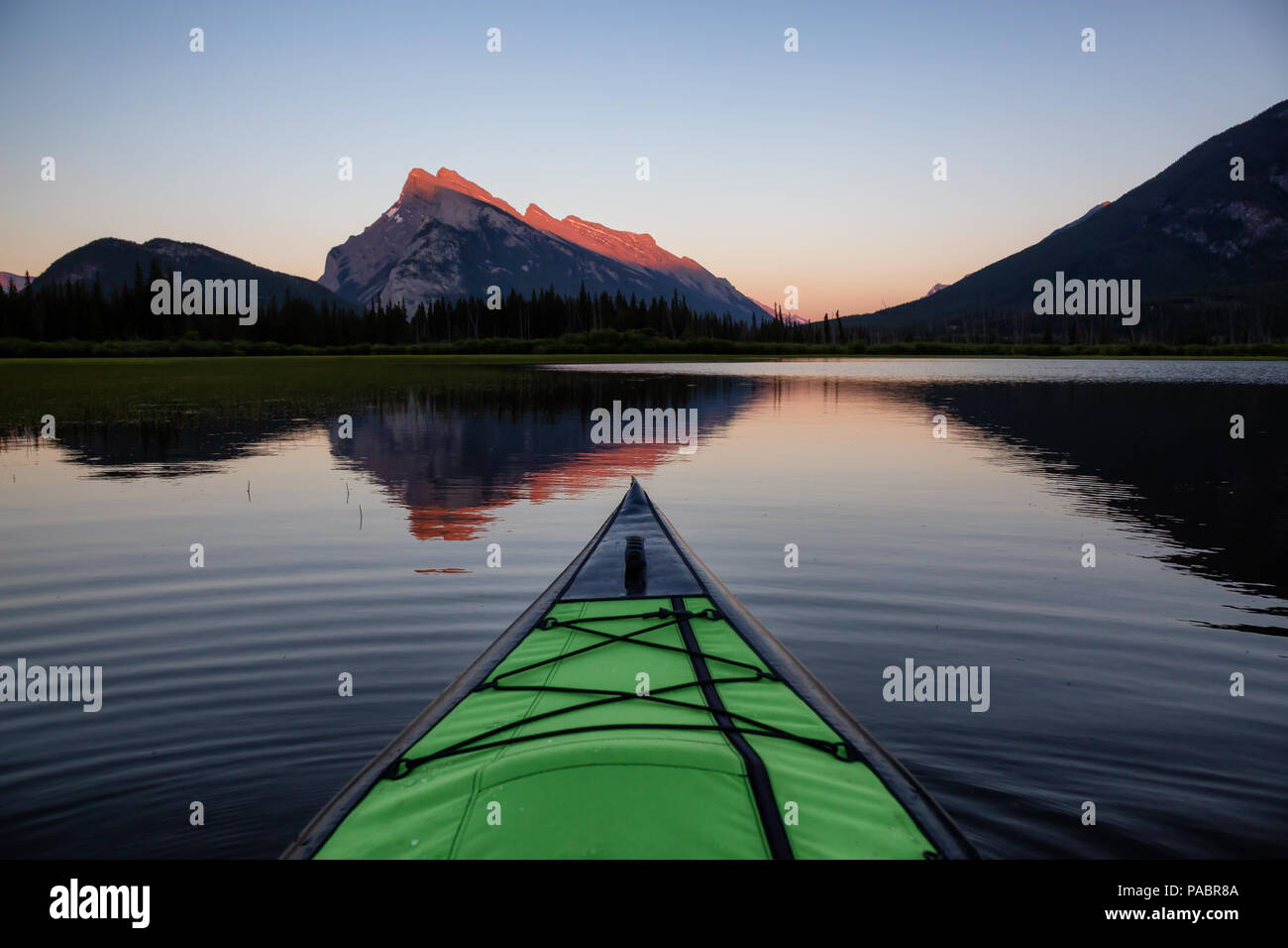 Kayaking in a beautiful lake surrounded by the Canadian Mountain ...