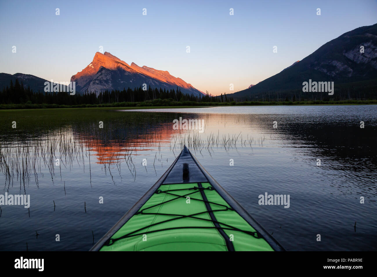 Kayaking in a beautiful lake surrounded by the Canadian Mountain ...