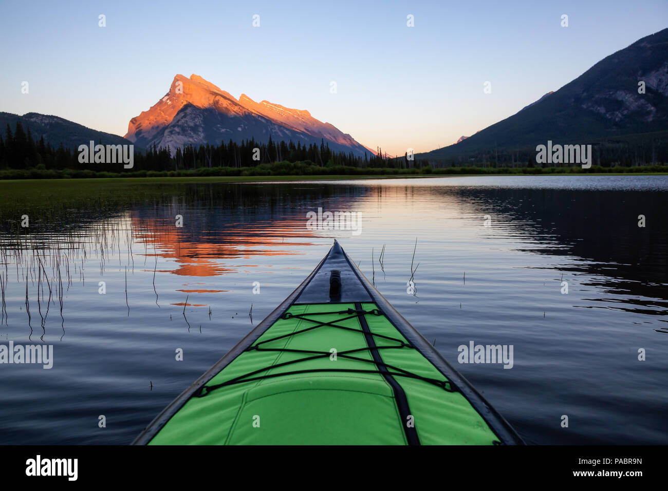 Kayaking in a beautiful lake surrounded by the Canadian Mountain ...