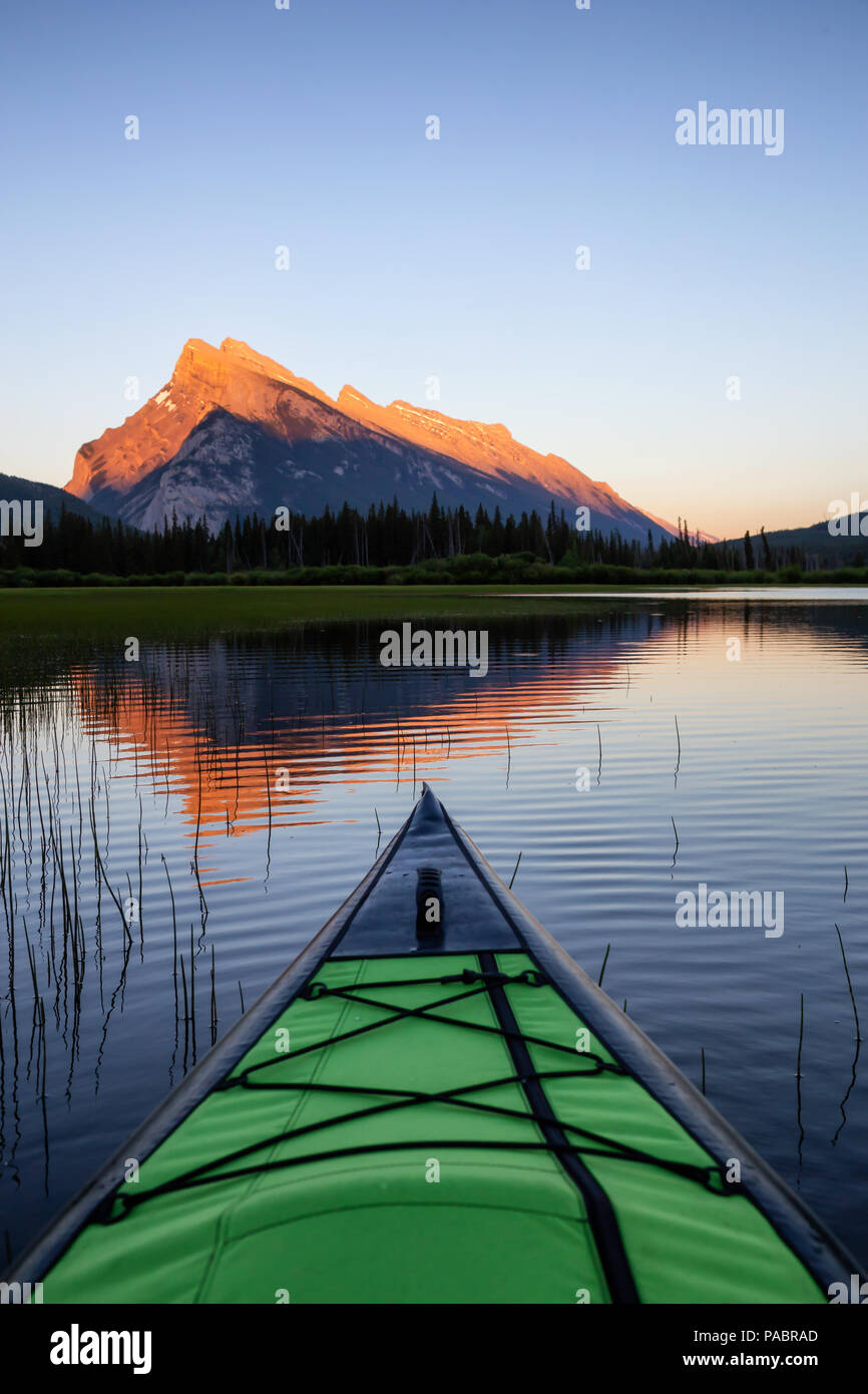 Kayaking in a beautiful lake surrounded by the Canadian Mountain ...