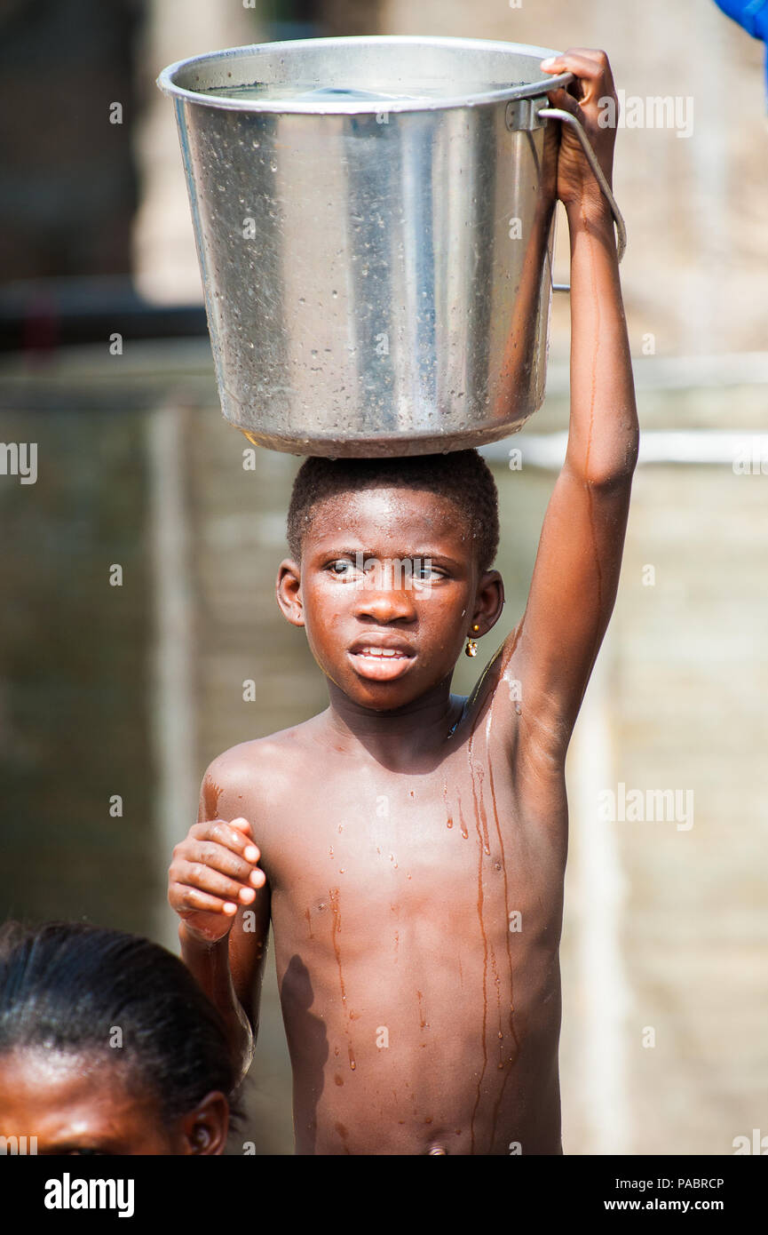 ACCRA, GHANA - MARCH 2, 2012: Unidentified Ghanaian boy with a bucket ...