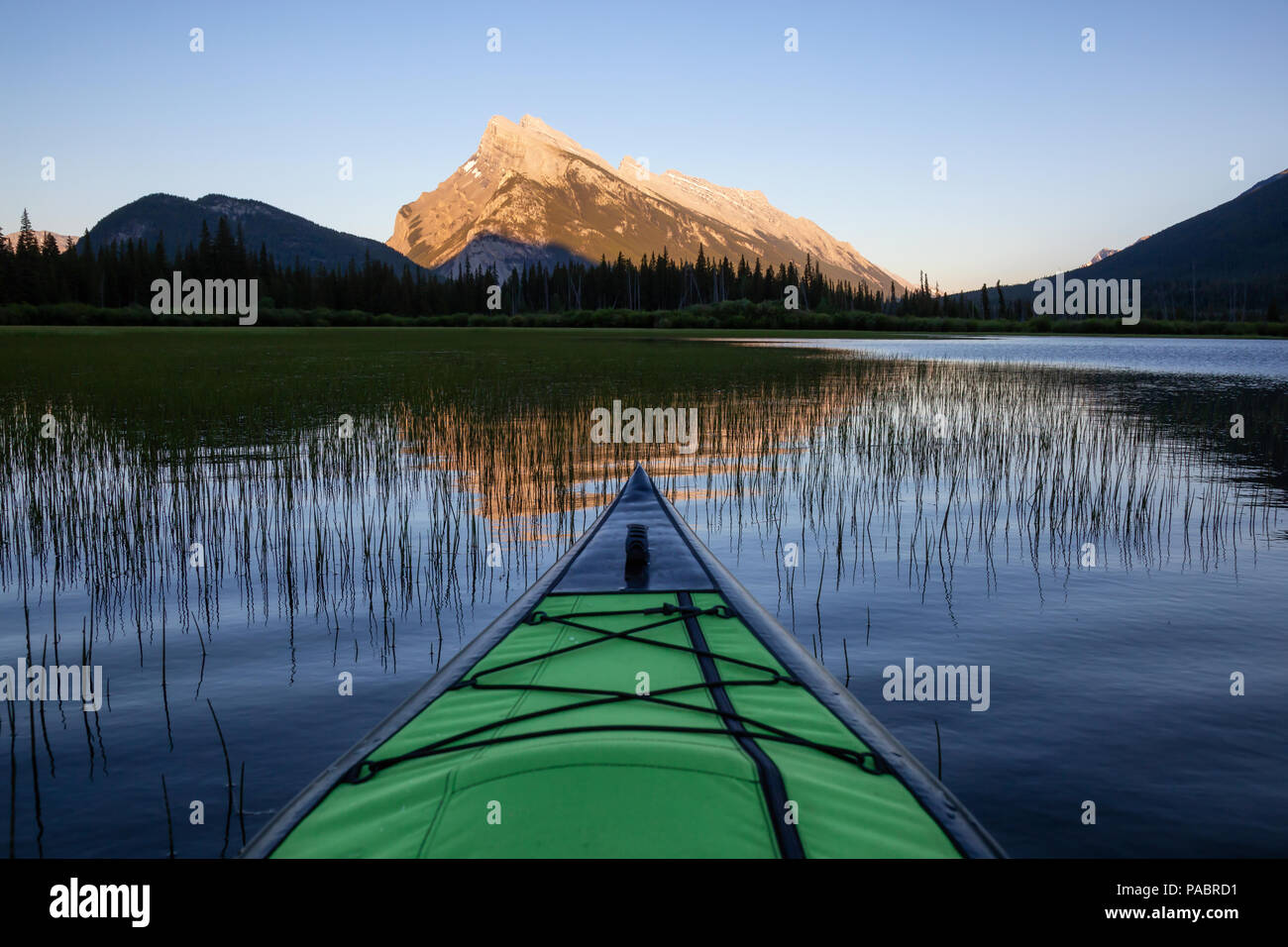 Kayaking in a beautiful lake surrounded by the Canadian Mountain ...