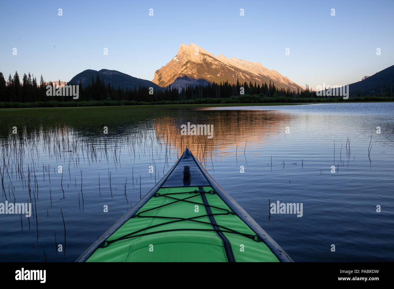 Kayaking in a beautiful lake surrounded by the Canadian Mountain ...
