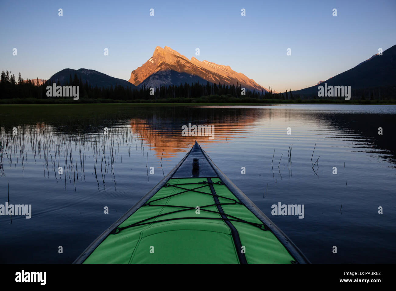 Kayaking in a beautiful lake surrounded by the Canadian Mountain ...