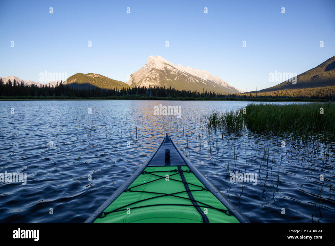 Kayaking in a beautiful lake surrounded by the Canadian Mountain ...