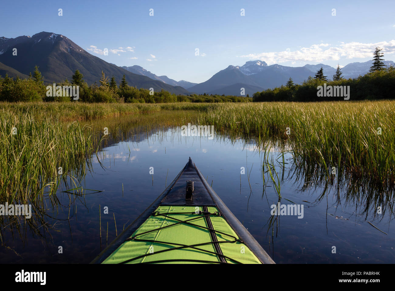 Kayaking in a beautiful lake surrounded by the Canadian Mountain ...