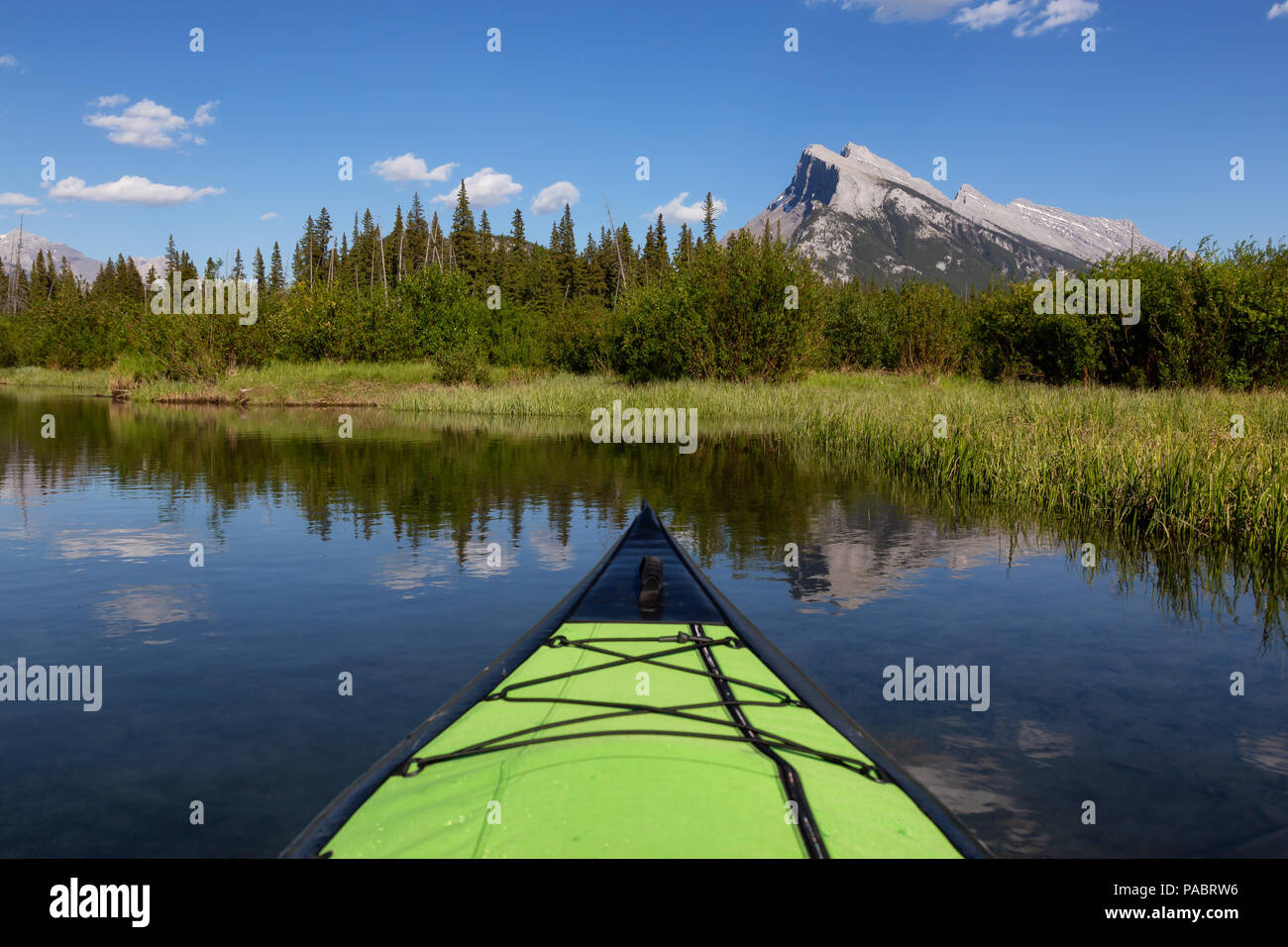 Kayaking in a beautiful lake surrounded by the Canadian Mountain ...