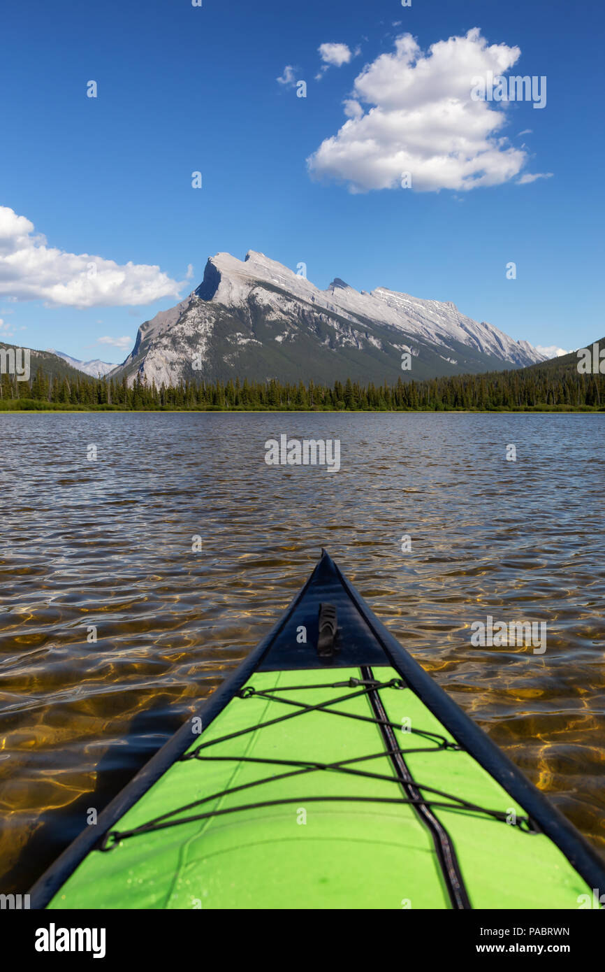 Kayaking in a beautiful lake surrounded by the Canadian Mountain ...