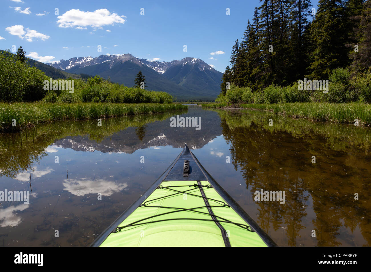 Kayaking in a beautiful lake surrounded by the Canadian Mountain ...