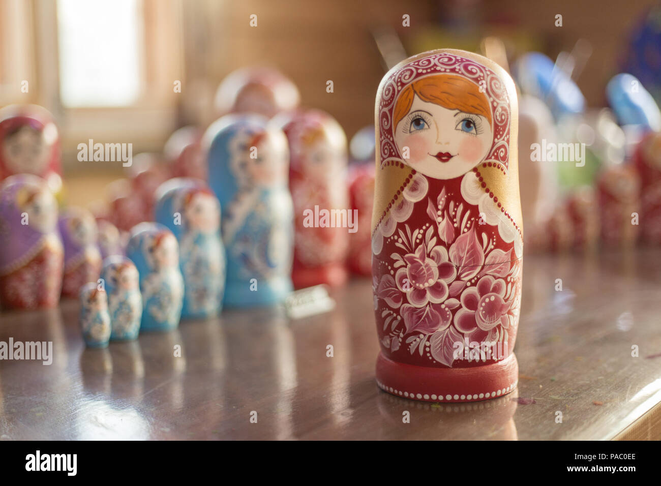 A Handmade Matrioshka on focus on a table with many other Matrioshkas ...