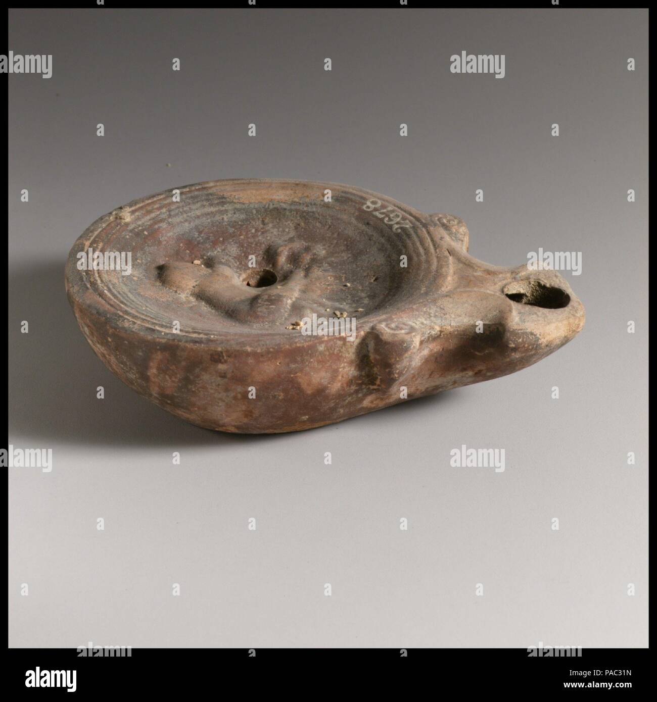 Lamp. Culture: Roman. Dimensions: Length: 3 7/8 in. (9.9 cm) Height: 1 ...
