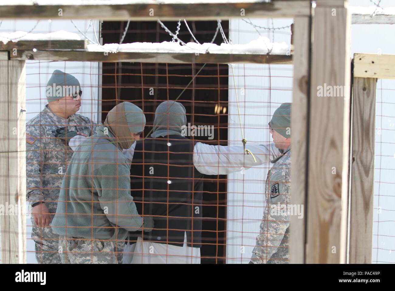 A prisoner is patted down and searched by three U.S. Army Soldiers from ...