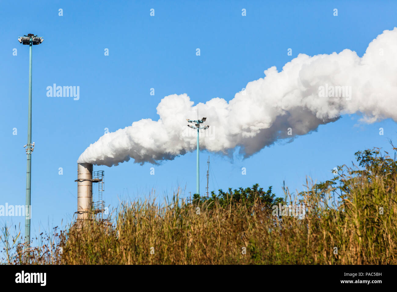Factory production chimney silo tower smoke across blue sky landscape ...