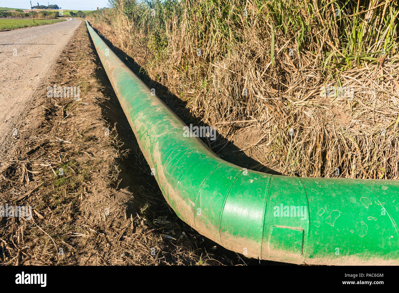 Factory long large green painted pipe transporting water from pump ...