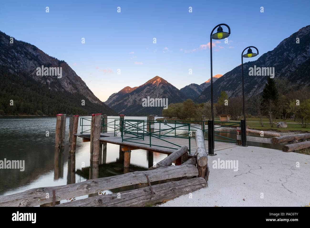 Pier, in the back mountains at lake Heiterwanger See in the evening ...