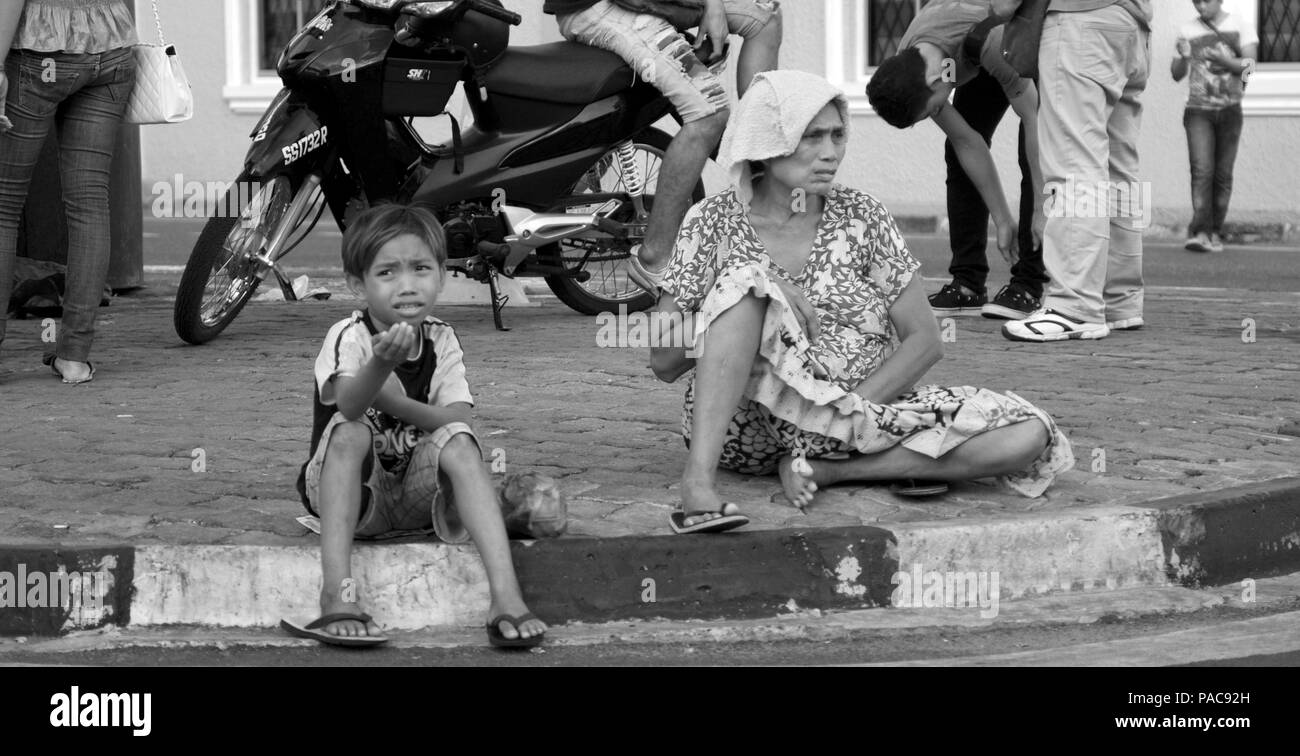 A Bajau lady and her son begging at the streets Stock Photo - Alamy