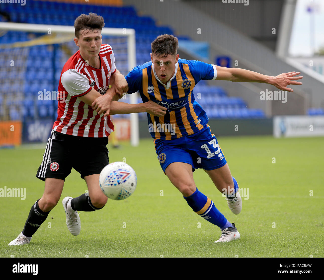 Shrewsbury Town's James Bolton (right) is tackled by Brentford's Tom ...