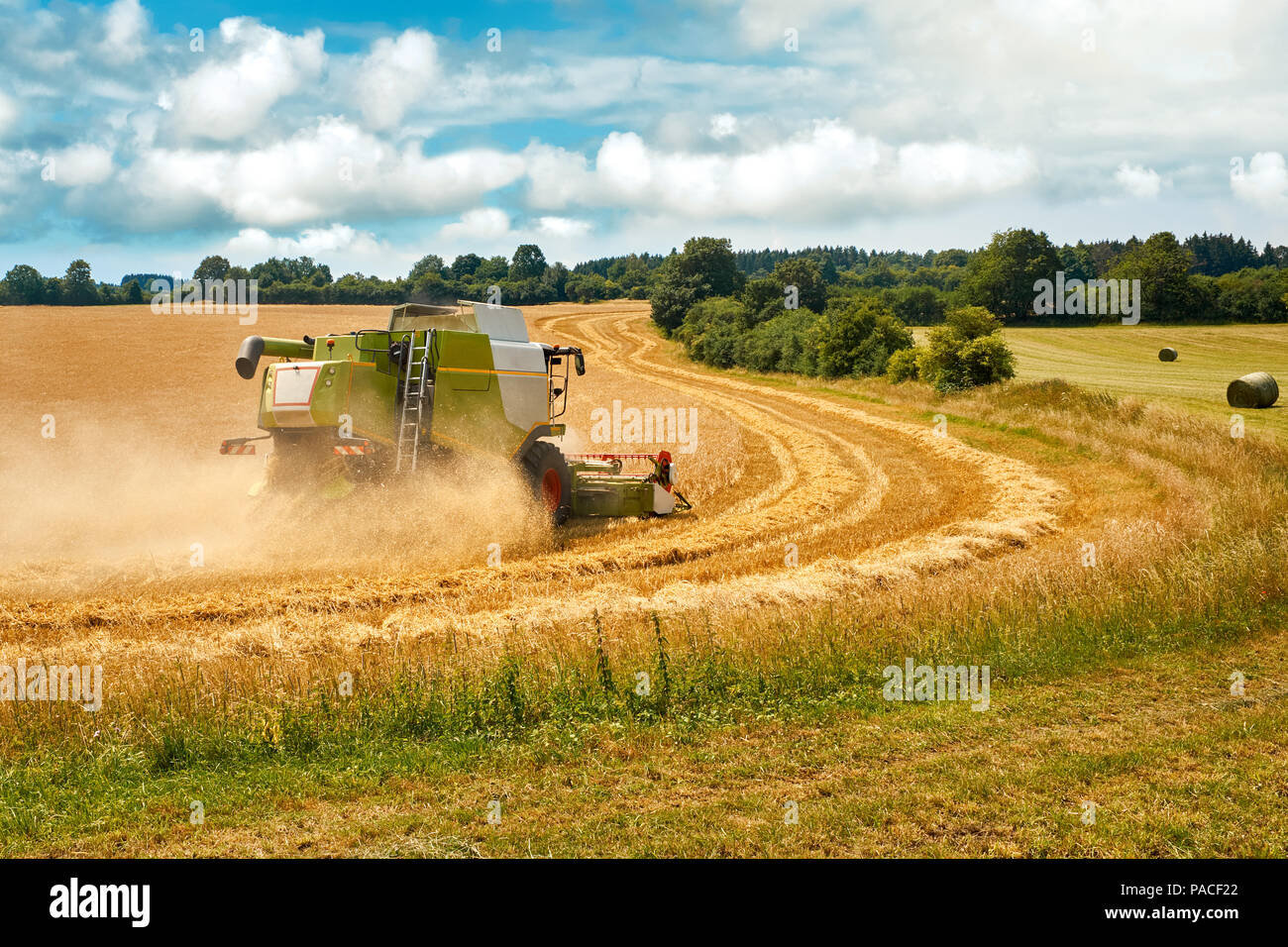 Working combine harvester in the field of wheat Stock Photo - Alamy