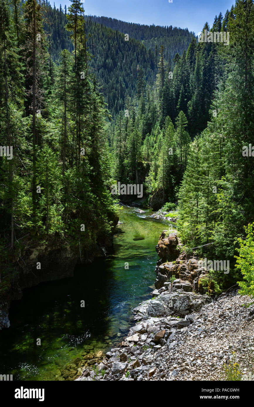 clear st joe river winds through mountainous hills covered in green ...