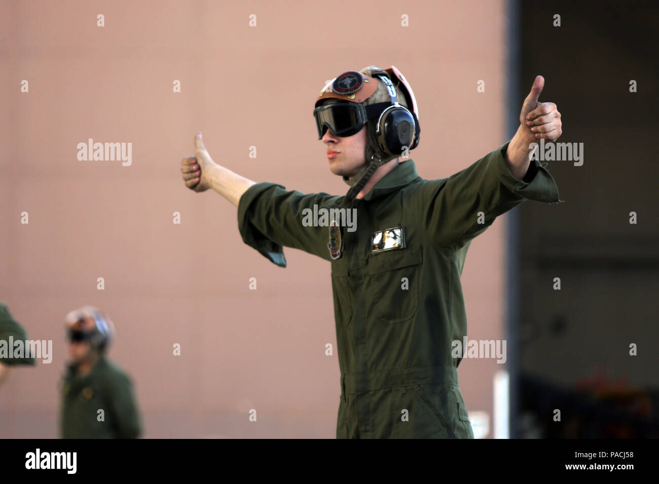 Marine Corps plane captain directs a TAV-8B Harrier pilot during pre ...