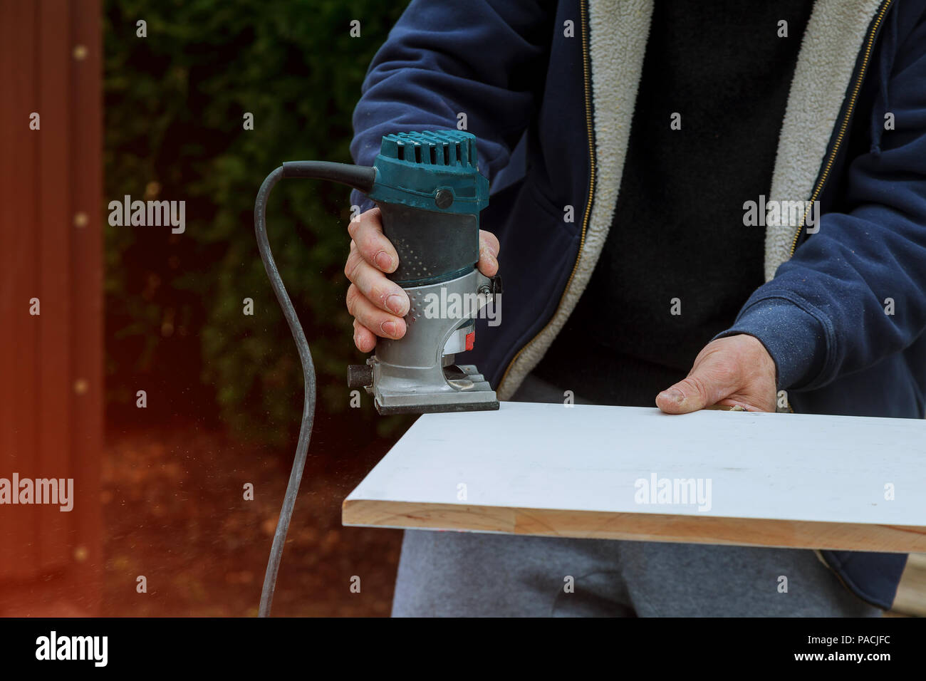 Carpenter hands of with Electronic Plunge Router in the workbench in ...