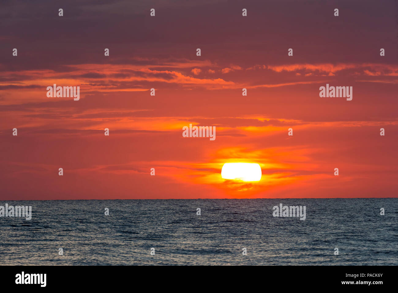 Setting sun over water with clouds hi-res stock photography and images ...