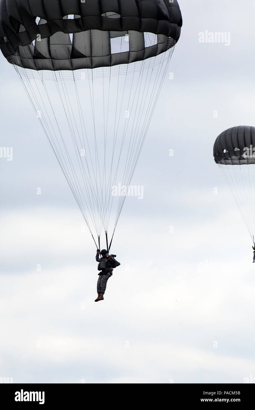A U.S. Army paratrooper parachutes to the ground following a jump from ...