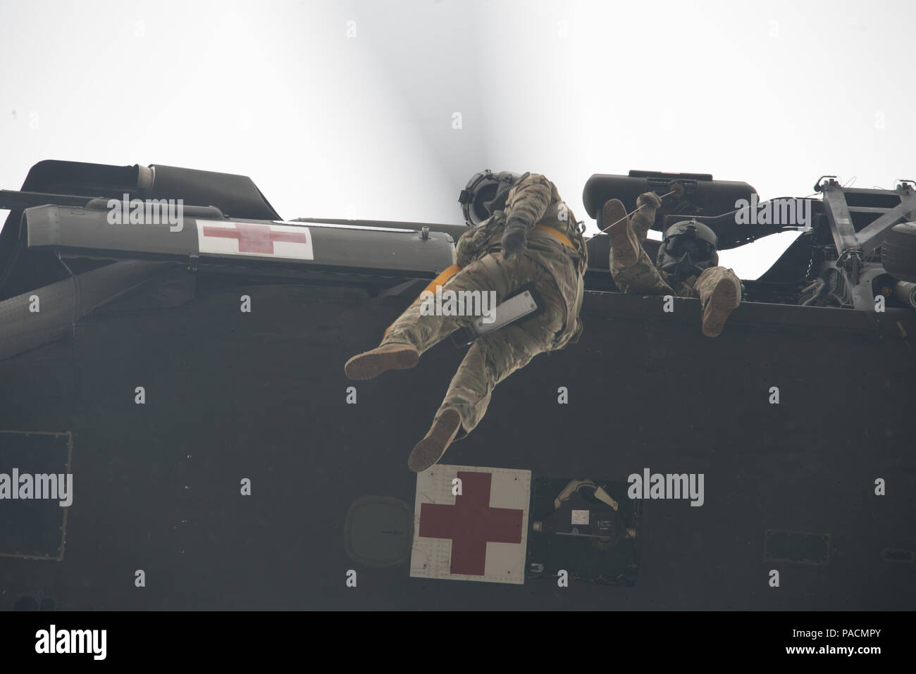 A U.S. Soldier, flight paramedic from a Black Hawk crew, is lowered to ...