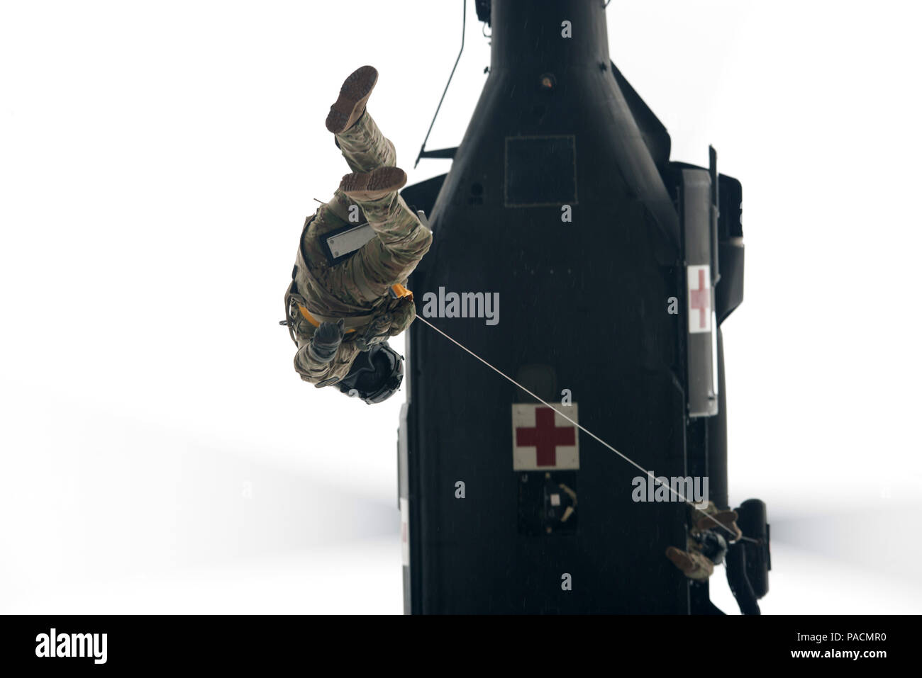 A U.S. Soldier, flight paramedic from a Black Hawk crew, is lowered to ...