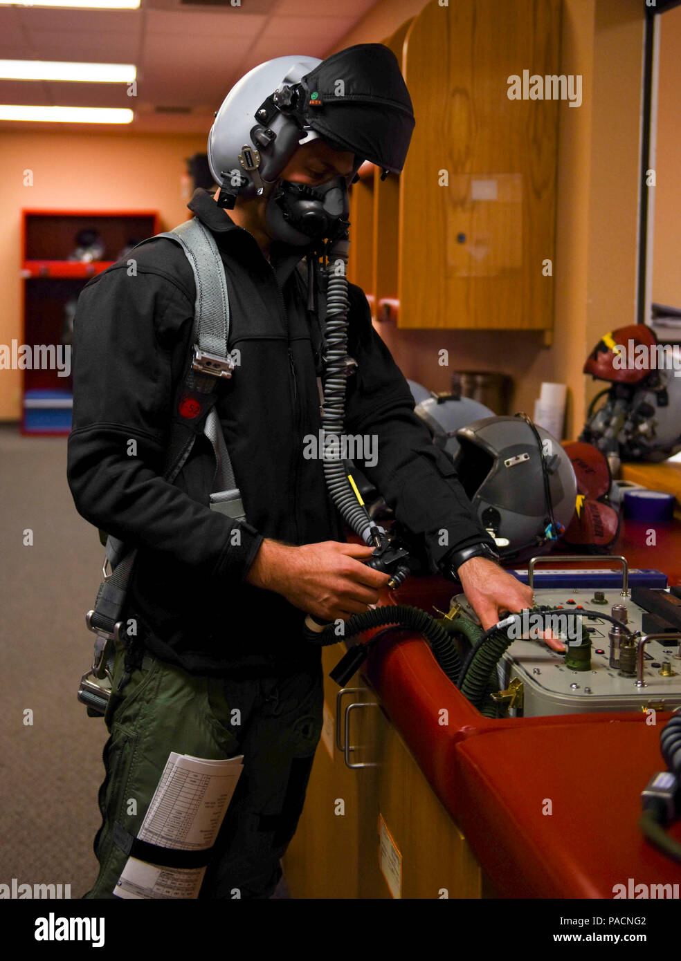 A pilot inspects his helmet before takeoff in the 72-hour sortie surge ...