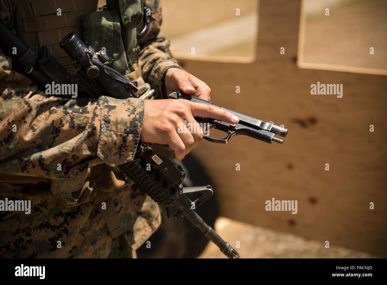 Cpl. Mario Lanza loads an M9 service pistol during a course of fire on ...