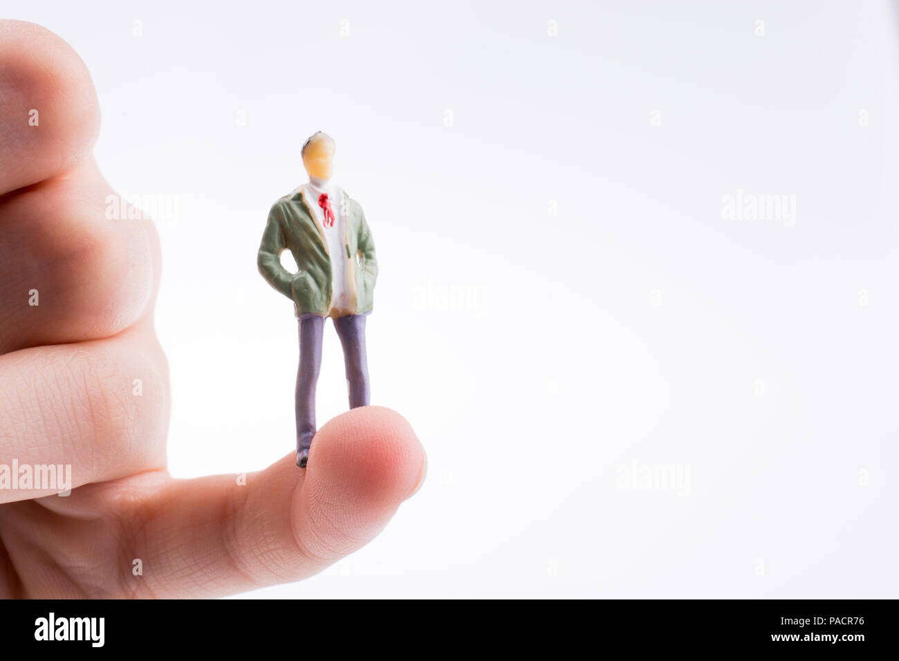 Hand holding a human figure on a white background Stock Photo - Alamy