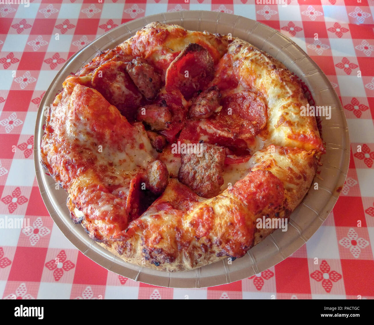 Small sausage and pepperoni pizza on a paper plate Stock Photo - Alamy