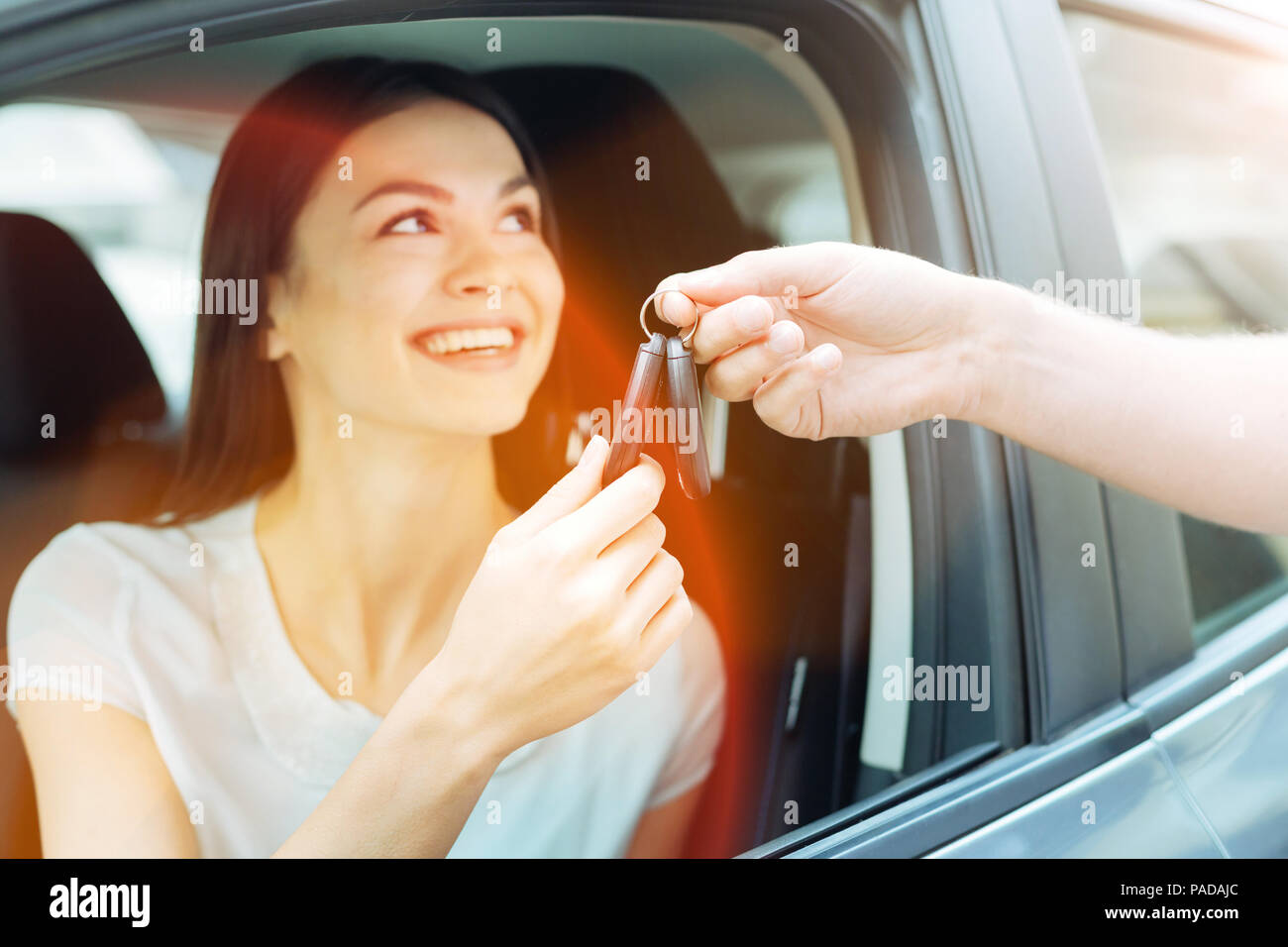 Smiling young driver getting her first keys Stock Photo - Alamy