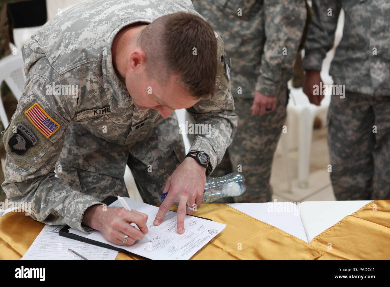 U.S. Army Cpt. Justin Kime with the 413th Civil Affairs Battalion signs ...