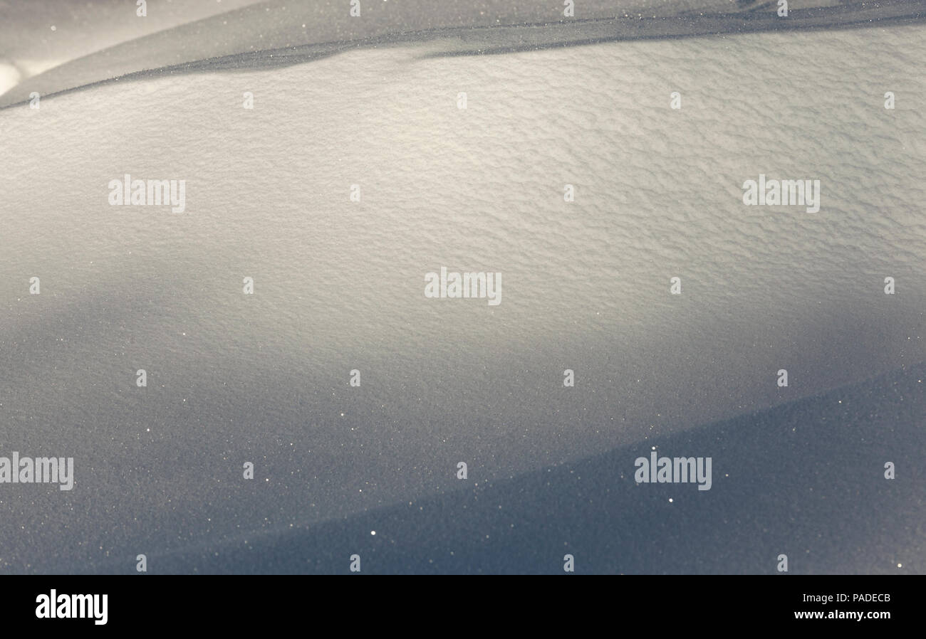 illuminated surface of snow, part of the surface is in shadow ...