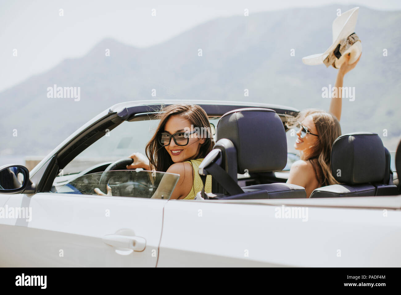 Young women with sunglasses driving her convertible top automobile on ...
