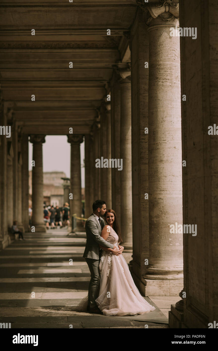 Young attractive newly married couple posing in Rome with beautiful and ...