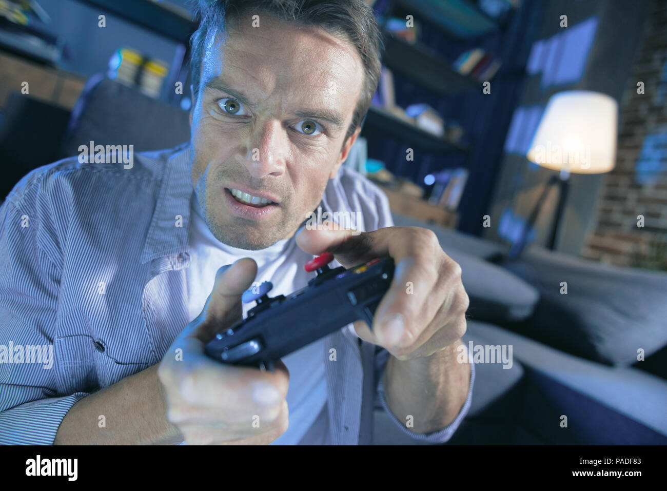 Serious determined man playing a video game Stock Photo - Alamy