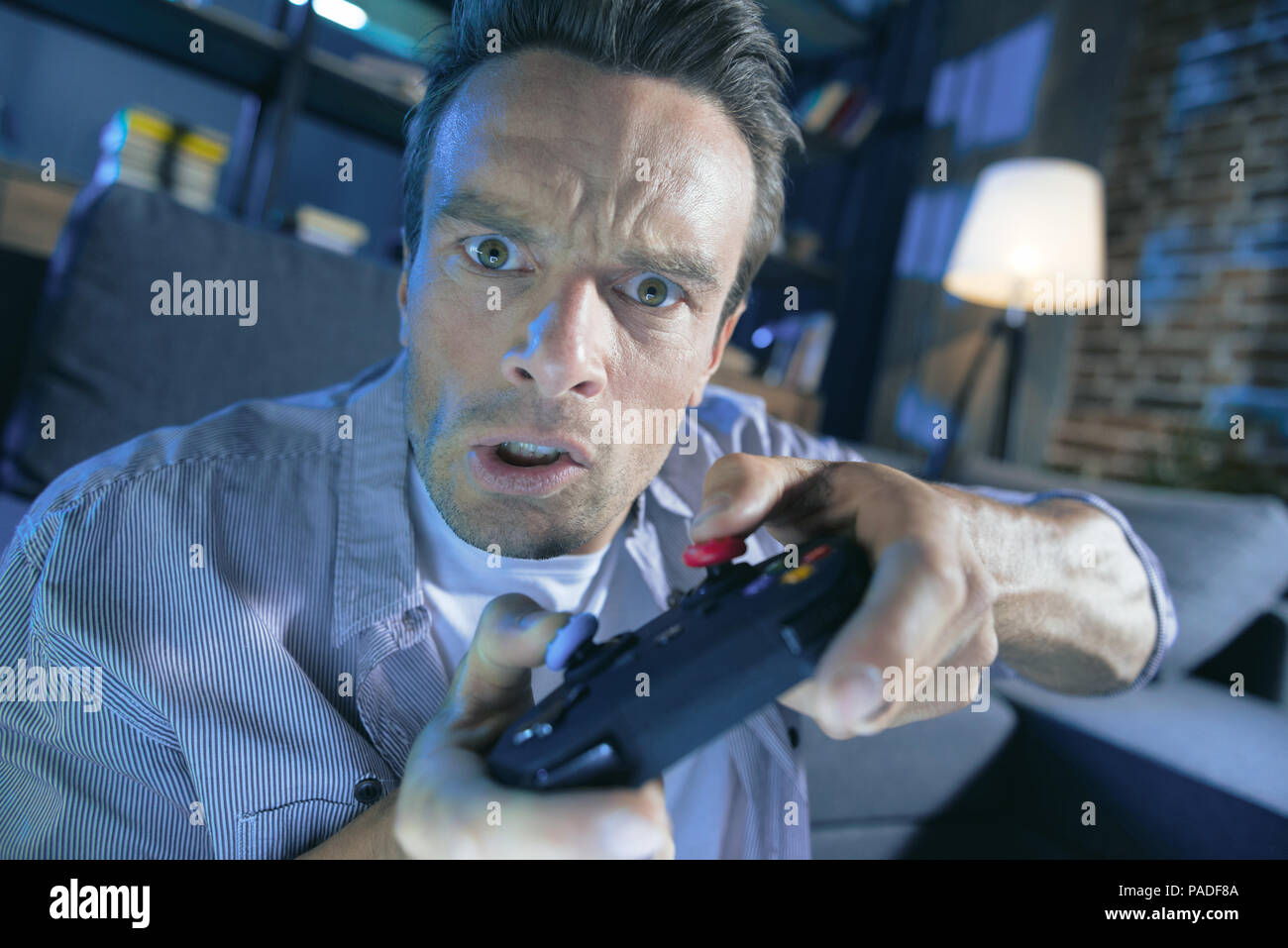 Nice emotional man using a game console Stock Photo - Alamy
