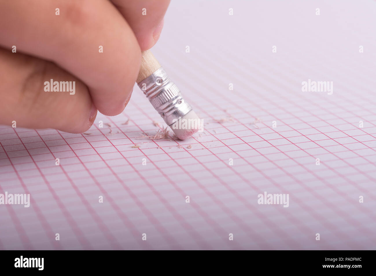 Pencil rubber held by a hand writing on a grid sheet Stock Photo - Alamy