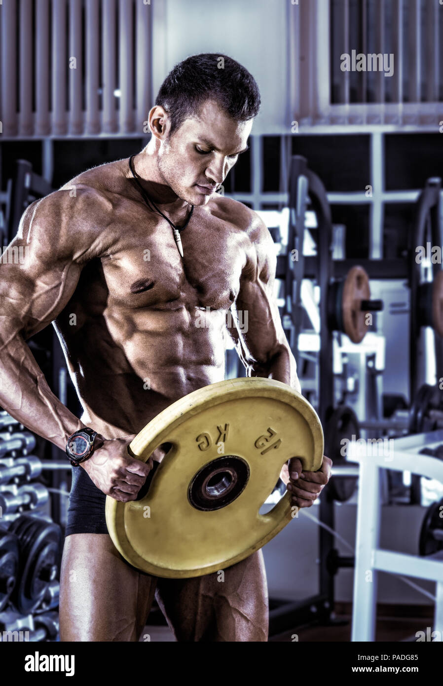 guy bodybuilder , execute exercise with weight in gym, vertical photo ...