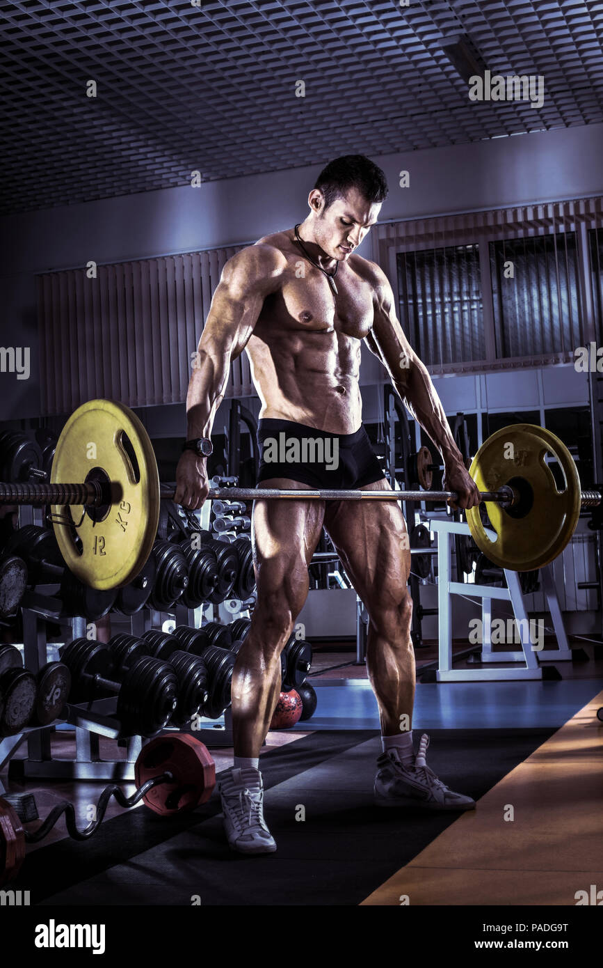 guy bodybuilder , execute exercise with weight in gym, vertical photo ...
