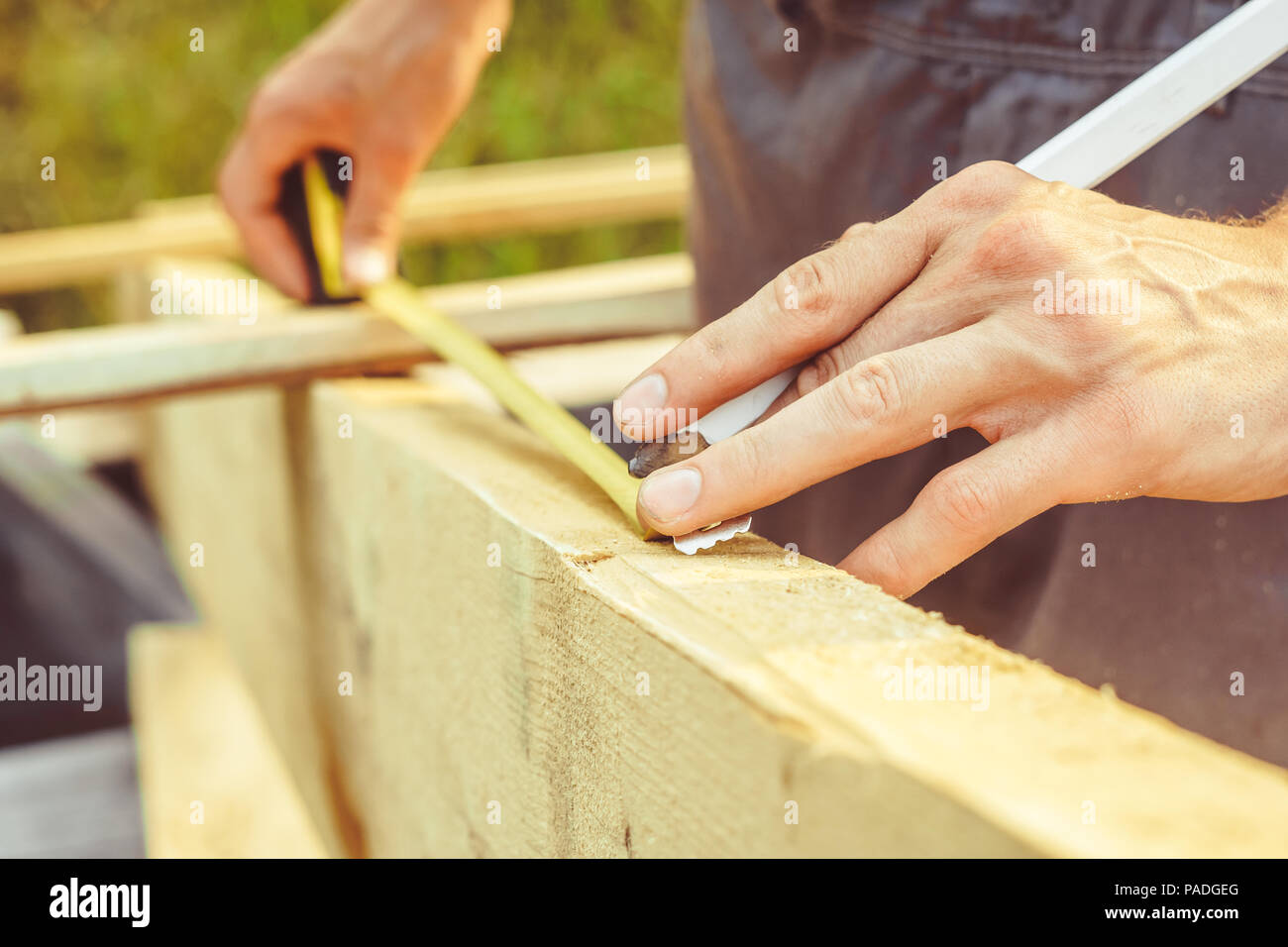 The worker makes measurements of a board with the help of a ruler, a ...
