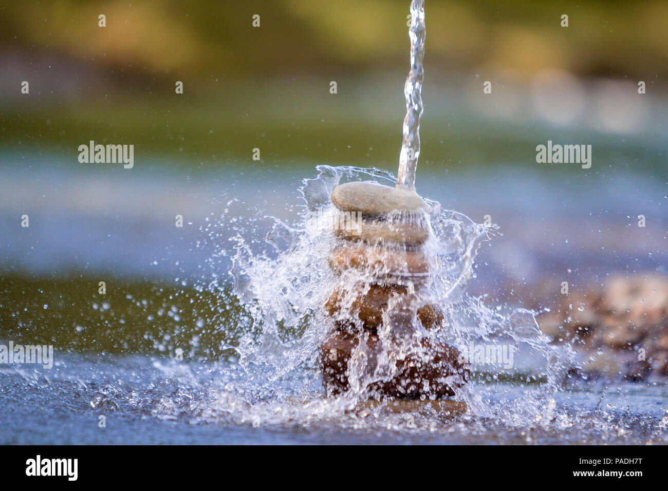 Close-up abstract image of water pouring down on rough natural brown ...